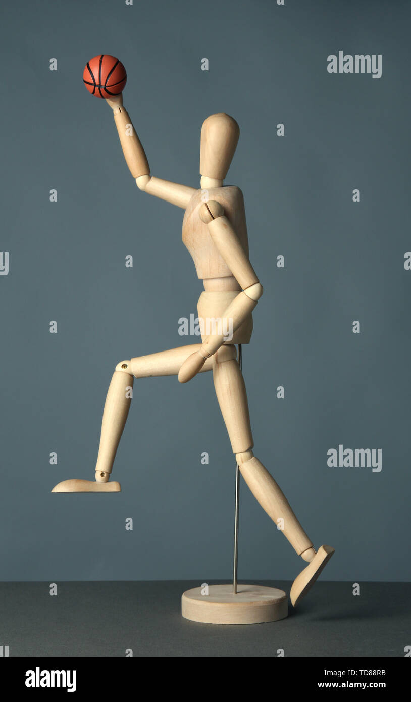 Wooden mannequin with basketball ball on grey background Stock Photo ...