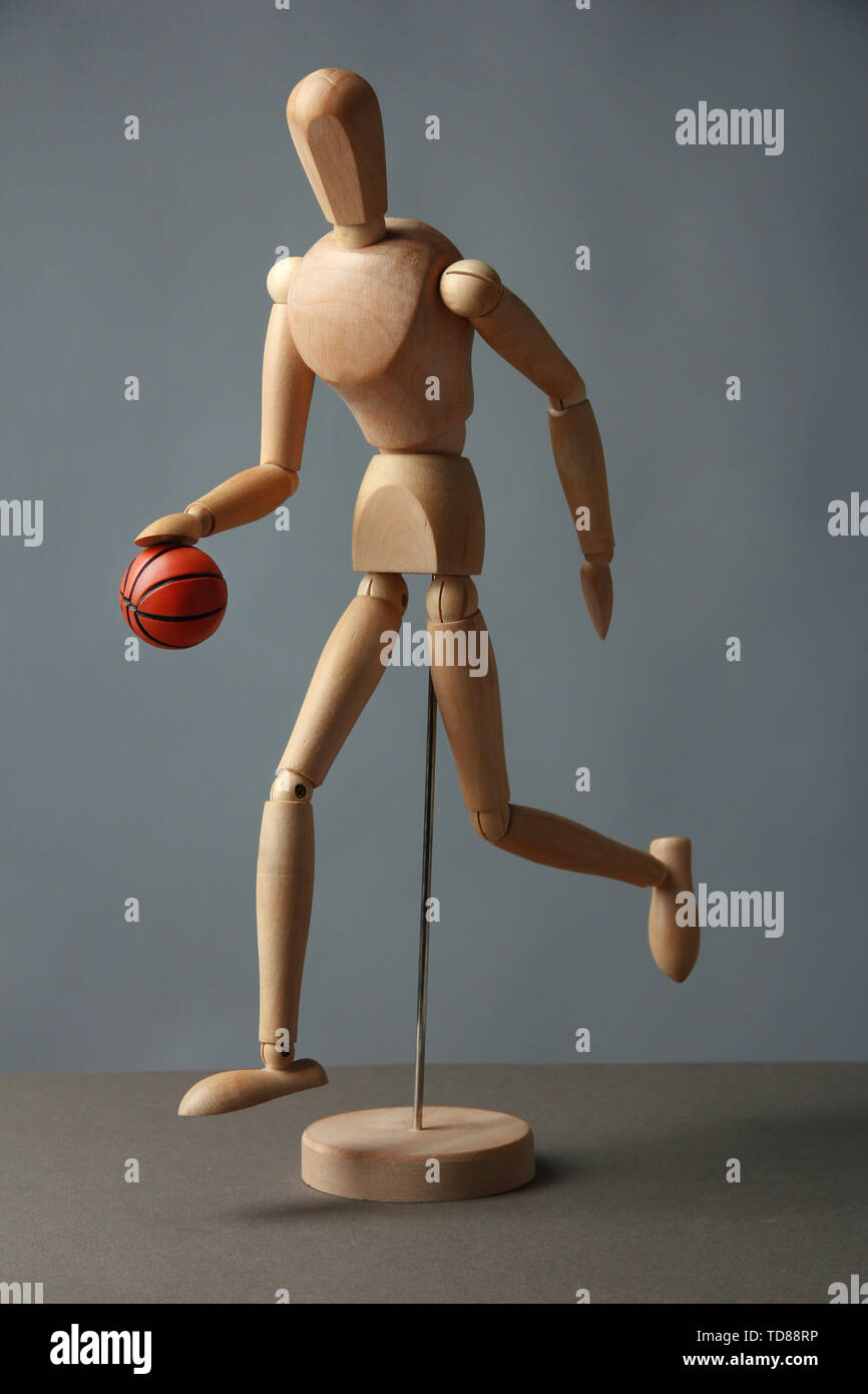 Wooden mannequin with basketball ball on grey background Stock Photo ...