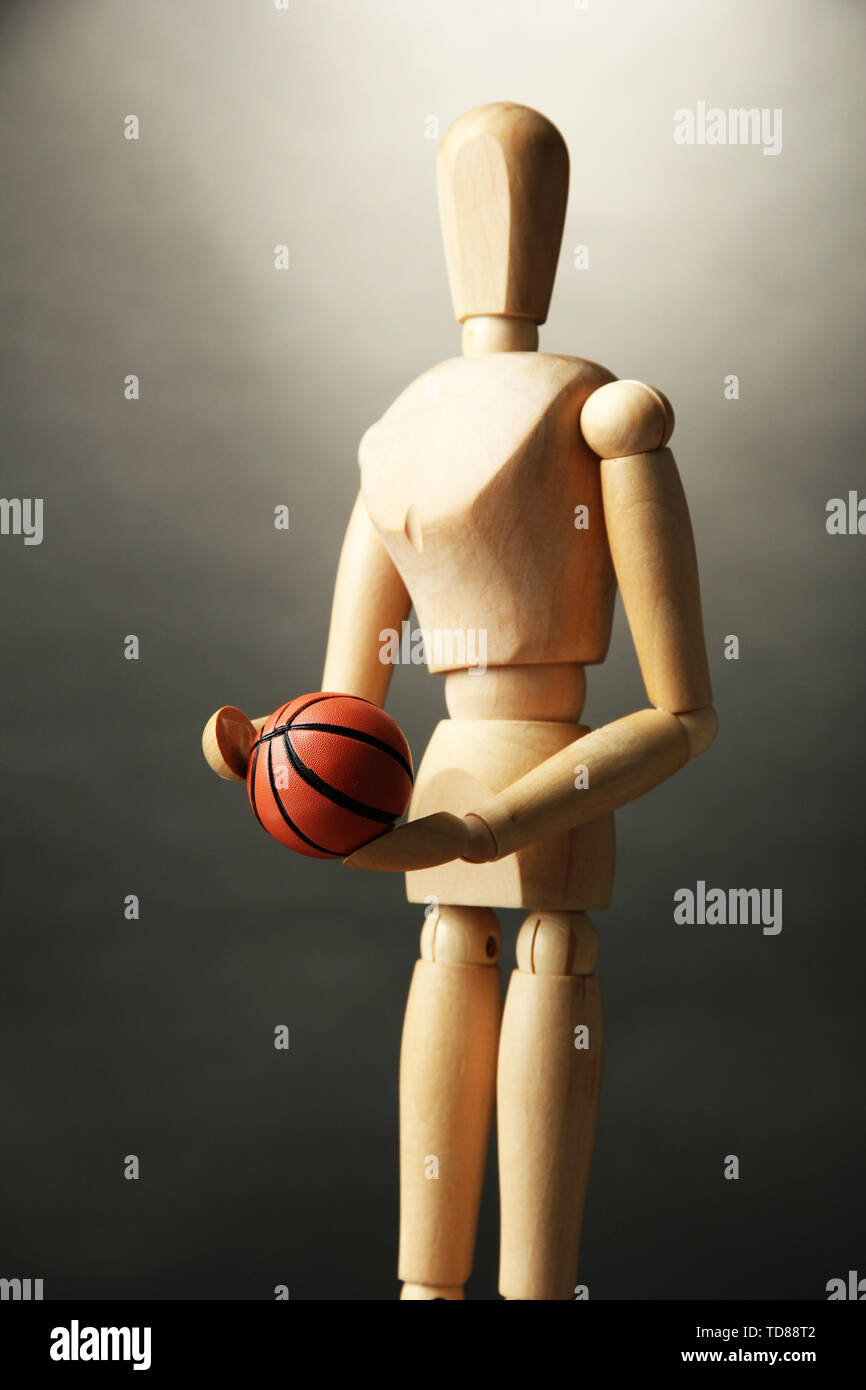 Wooden mannequin with basketball ball on grey background Stock Photo ...