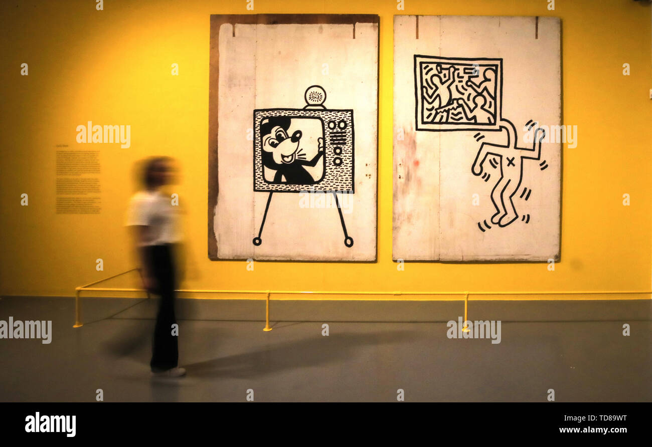 A visitor walks past artworks during a preview of the Keith Haring ...