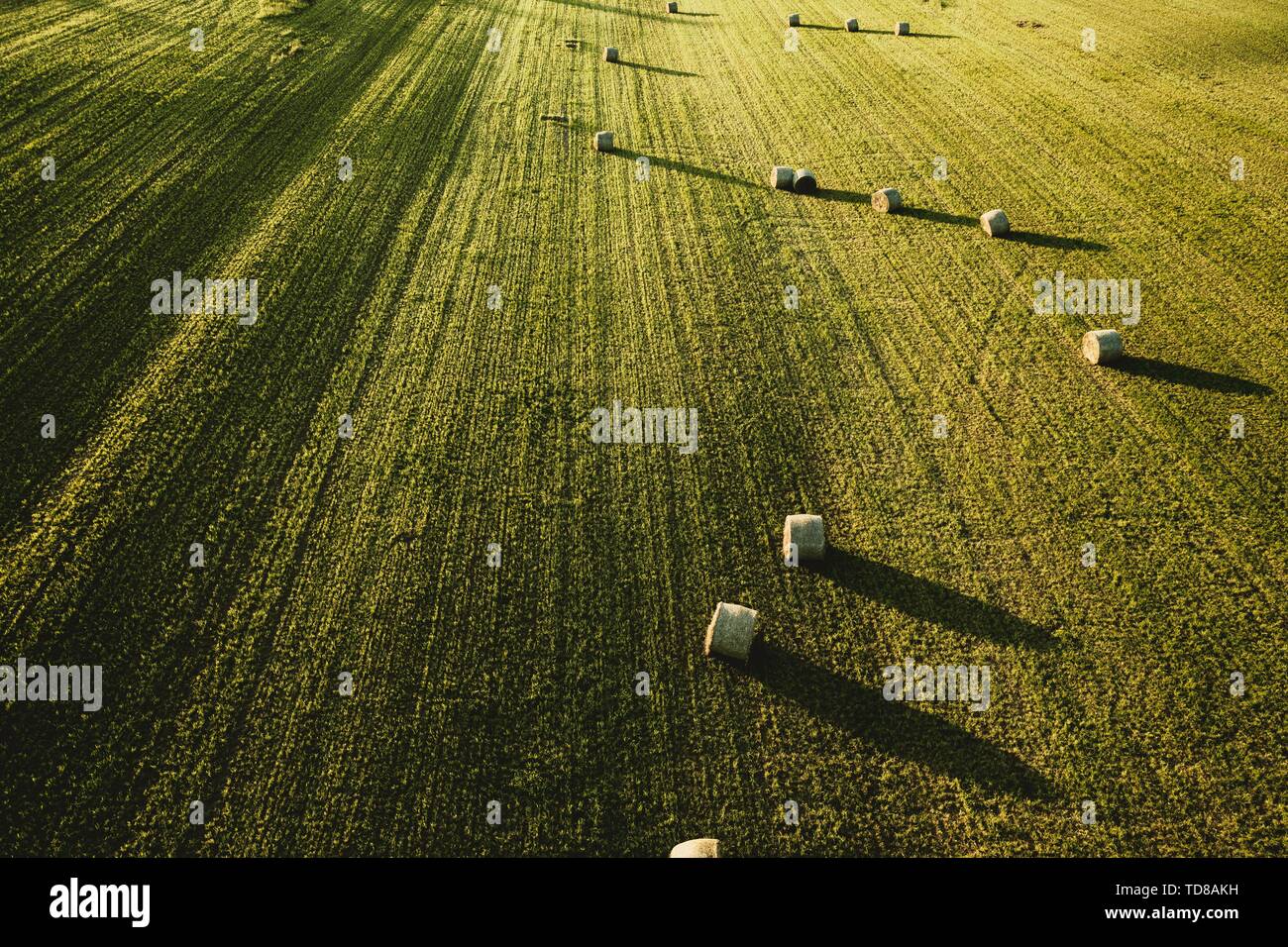 Large beautiful agricultural field with stacks of hay shot from above ...