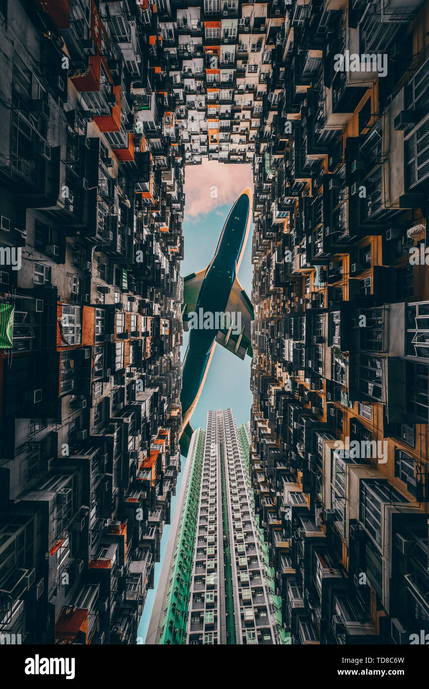 Plane skims over Hong Kong Monster Building Stock Photo - Alamy