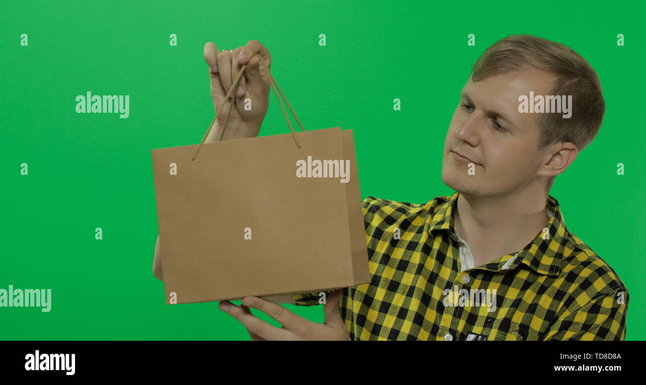 Handsome young man on green screen chroma key background with shopping ...
