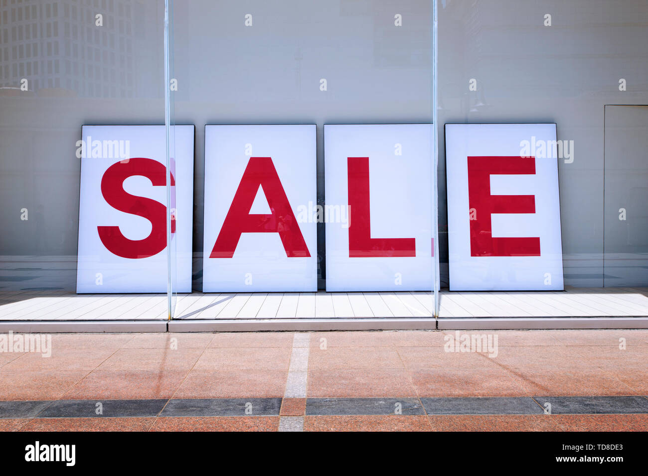 Sale poster in shop display window Stock Photo - Alamy