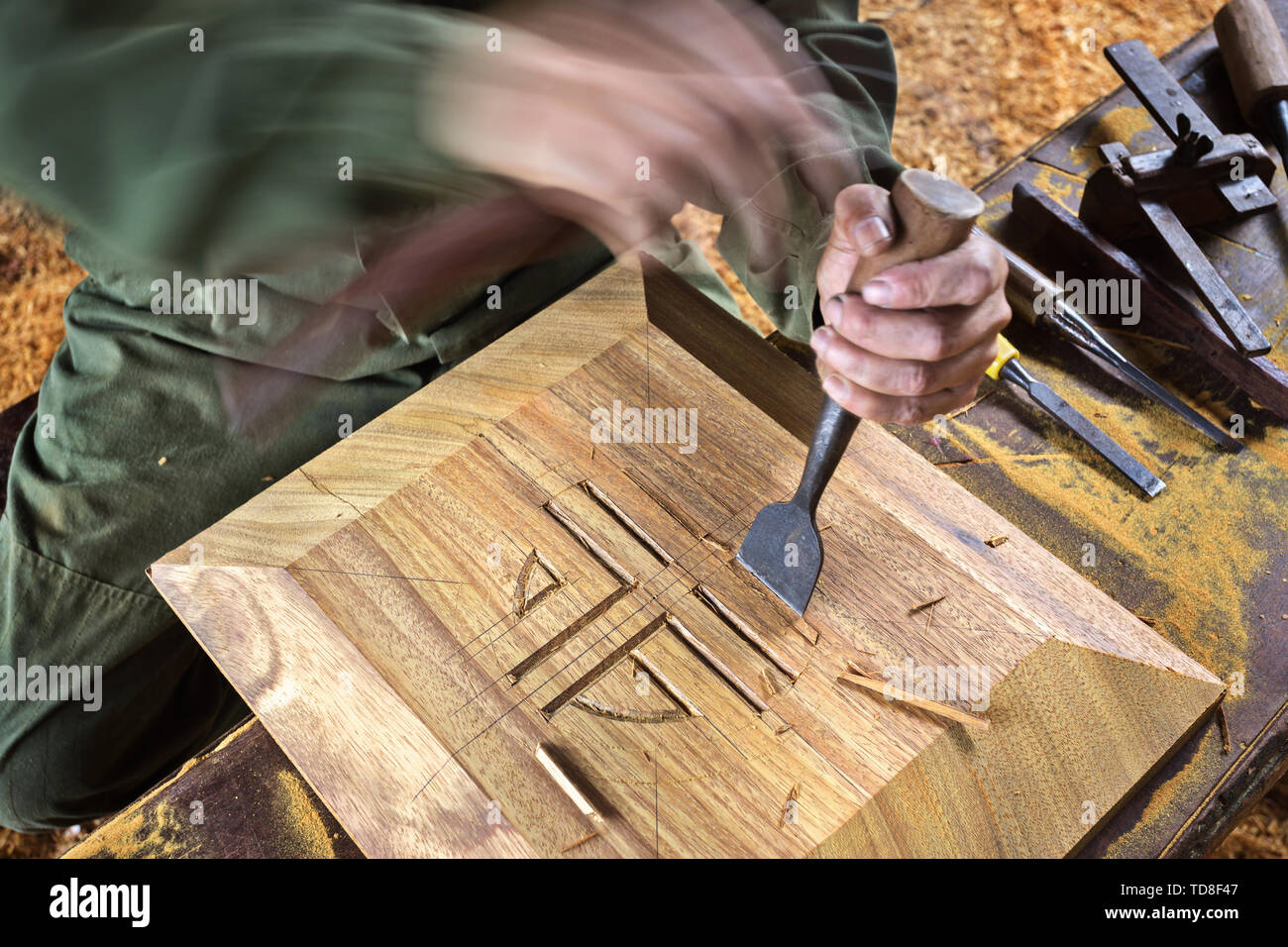 wood chisel carpenter tool hammer in hand working wooden background ...