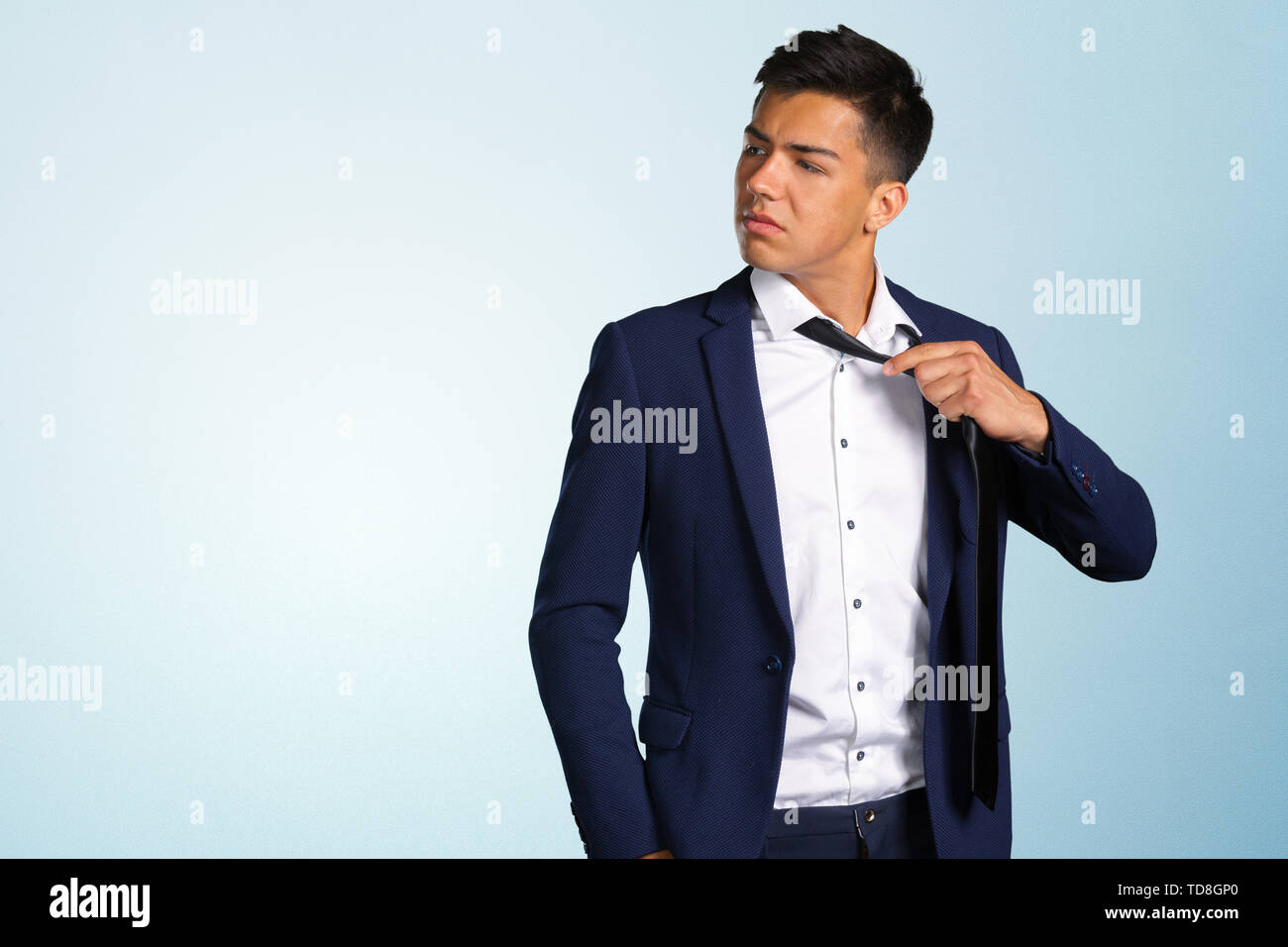 Confident young man adjusting his necktie Stock Photo - Alamy