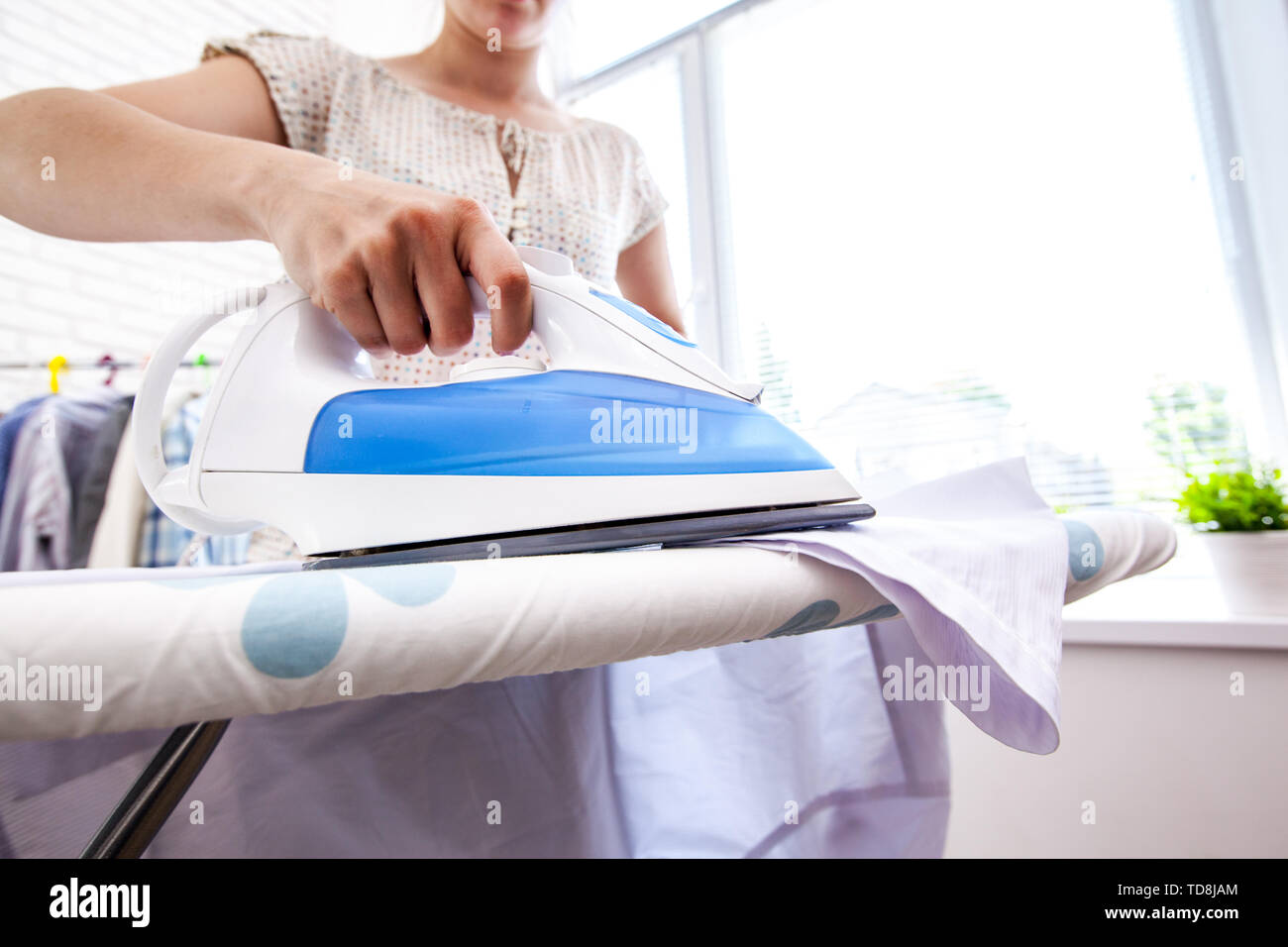 Closeup of woman ironing clothes on ironing board Stock Photo - Alamy