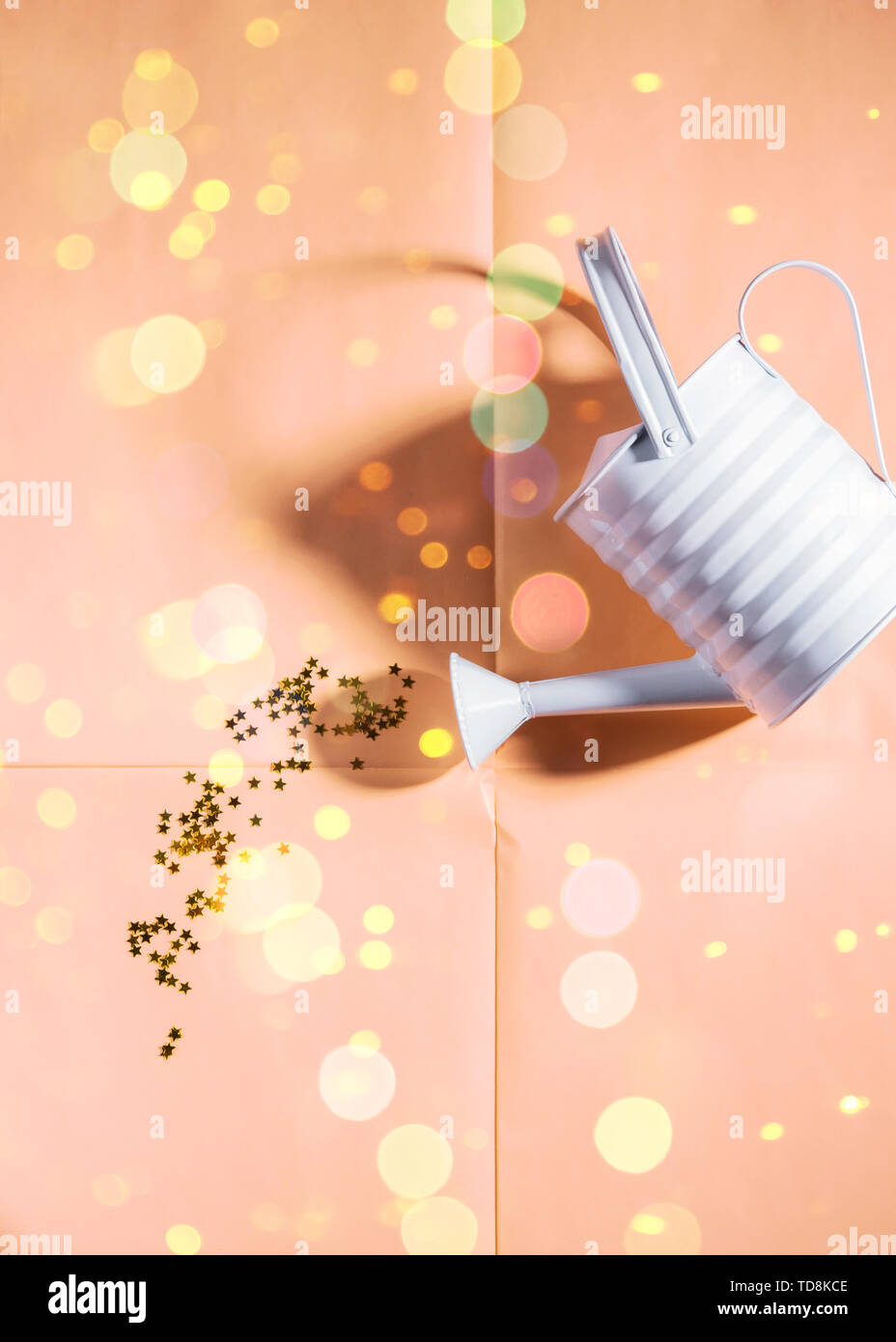 Watering can with magic stars on coral paper geometrical background ...