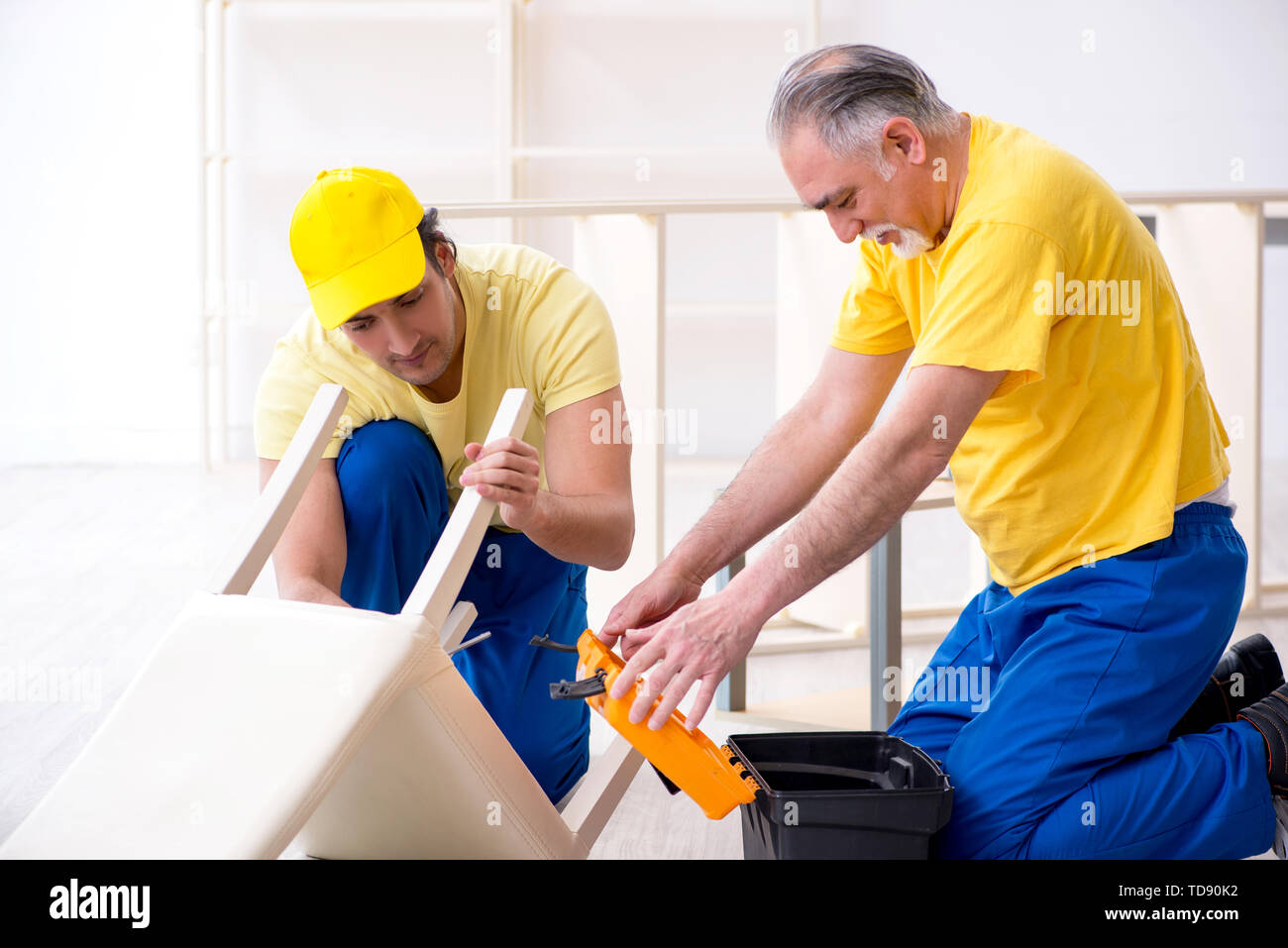 Two contractors carpenters working indoors Stock Photo - Alamy