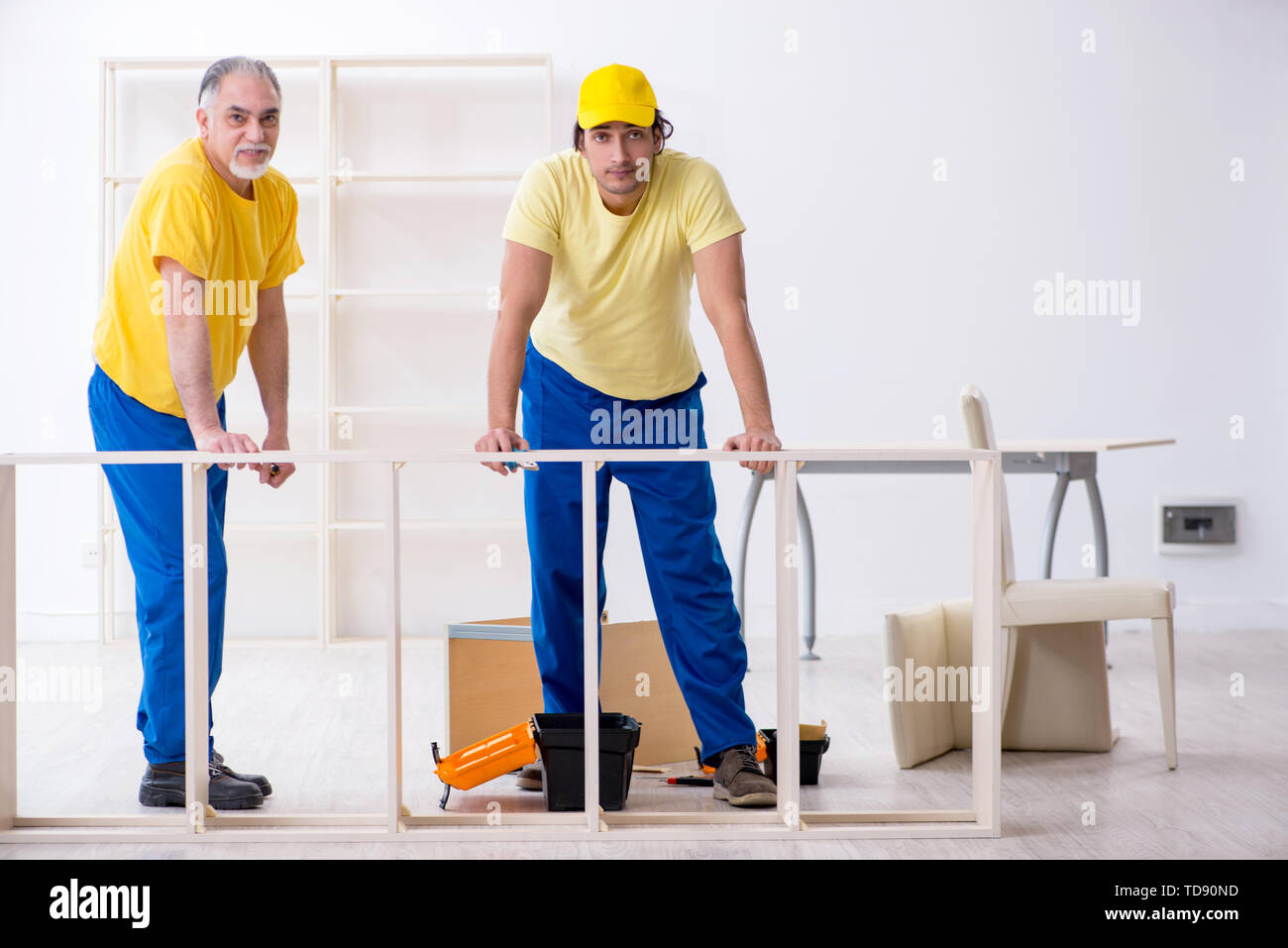 Two contractors carpenters working indoors Stock Photo - Alamy