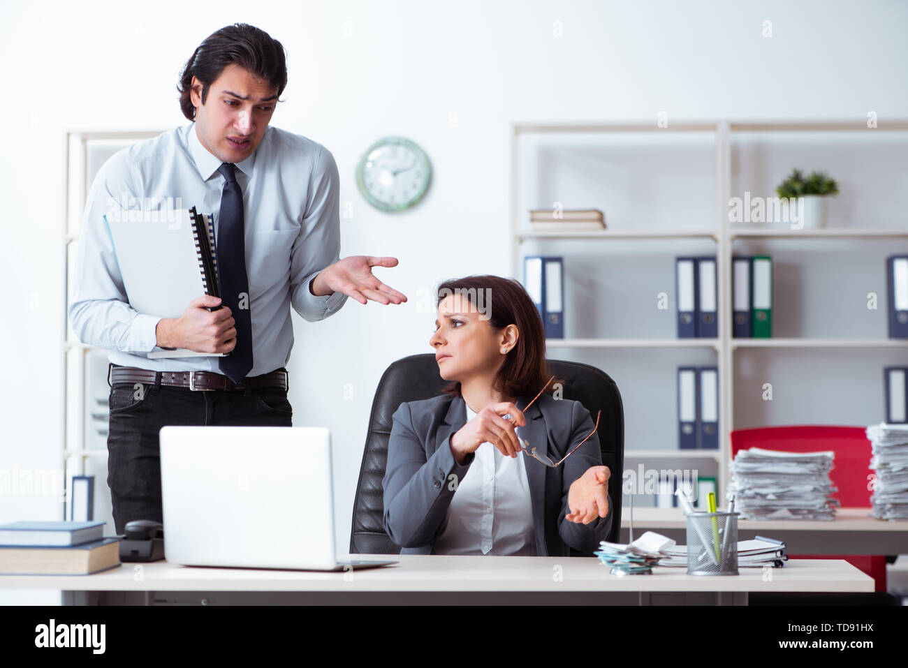 Old female boss and young male employee in the office Stock Photo - Alamy