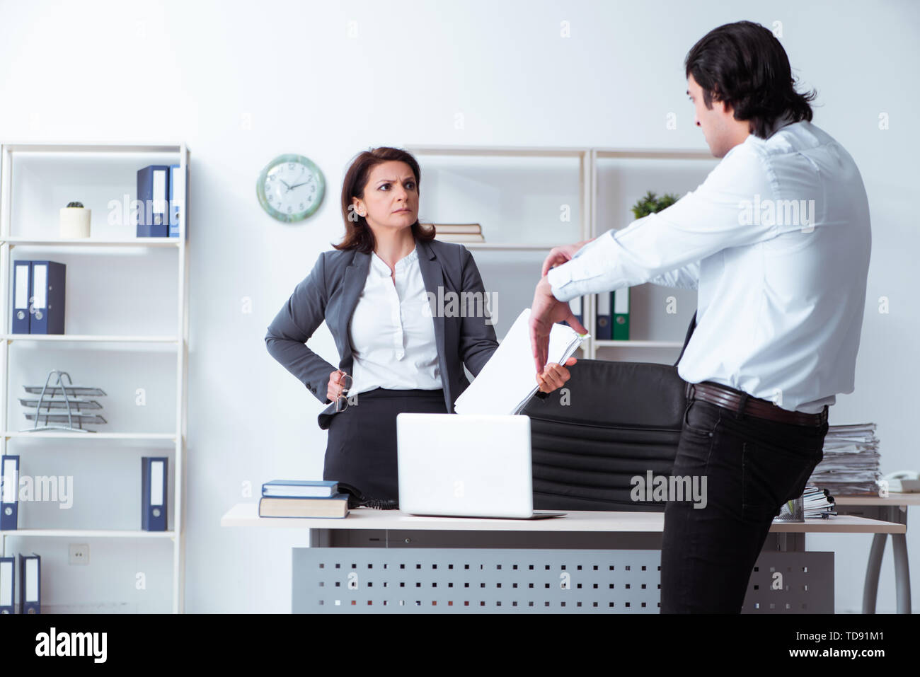 Old female boss and young male employee in the office Stock Photo - Alamy