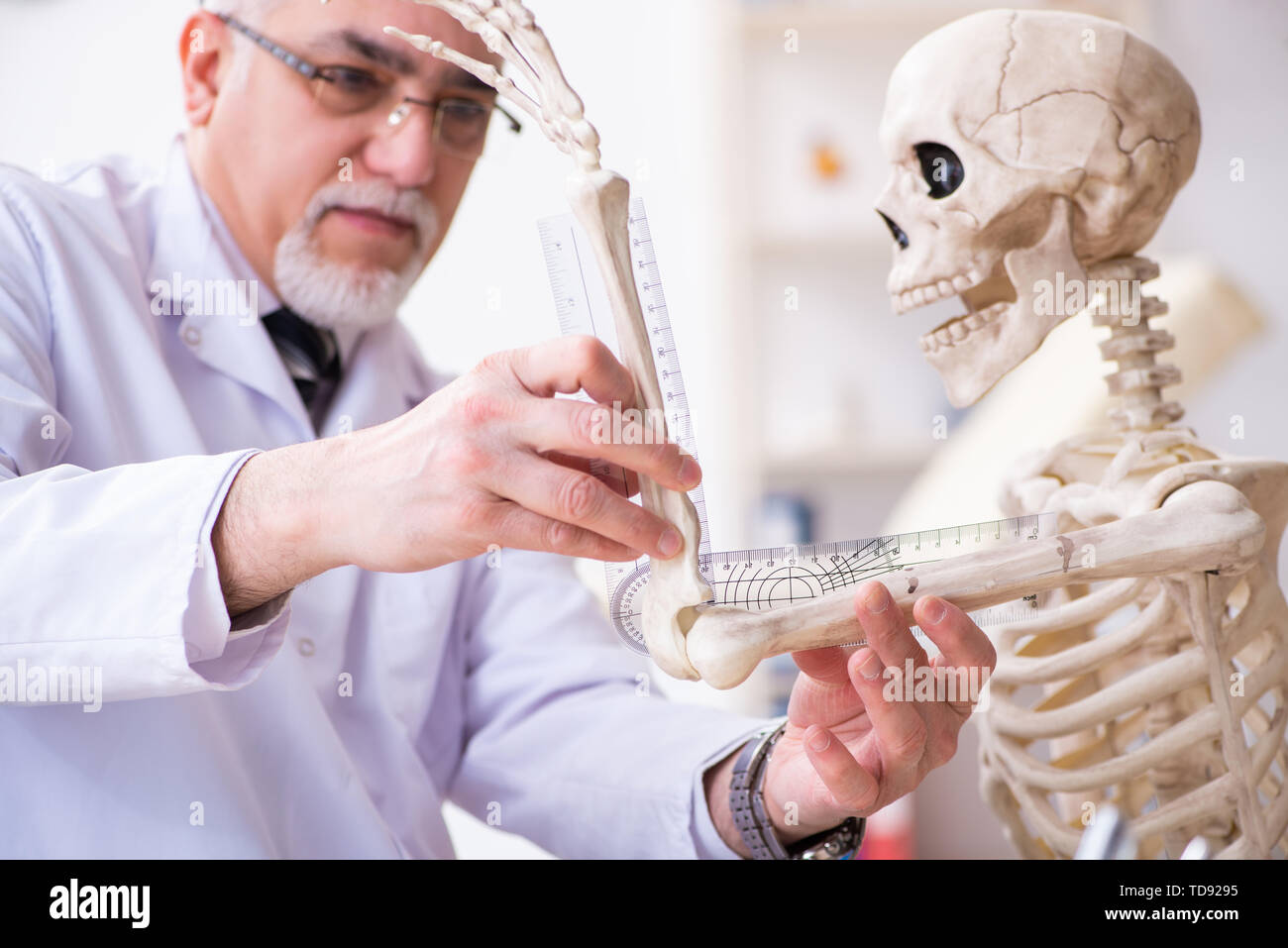 The aged male doctor with skeleton Stock Photo - Alamy
