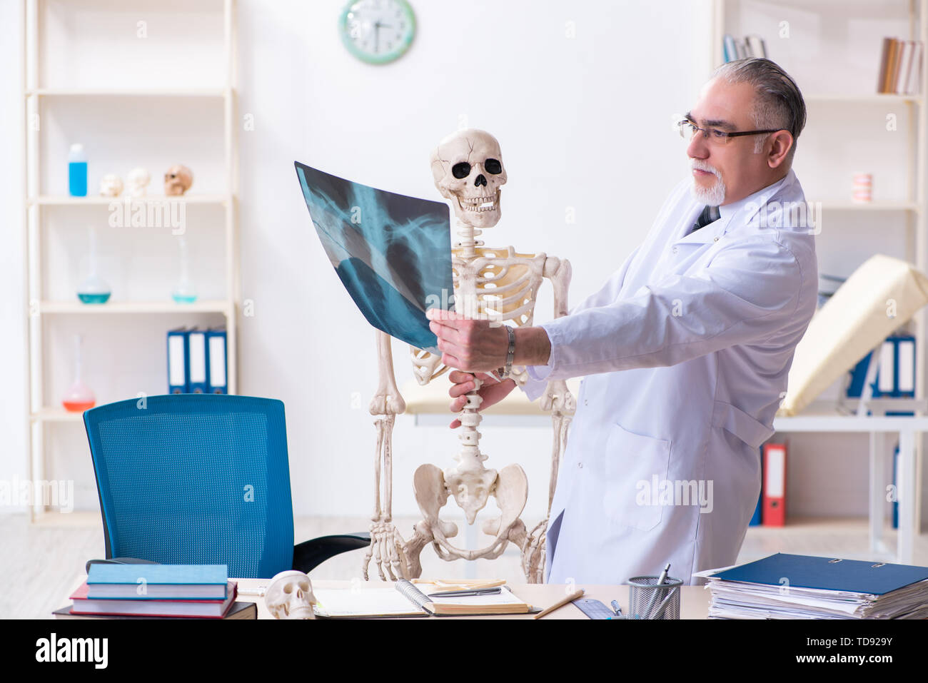 The aged male doctor with skeleton Stock Photo - Alamy