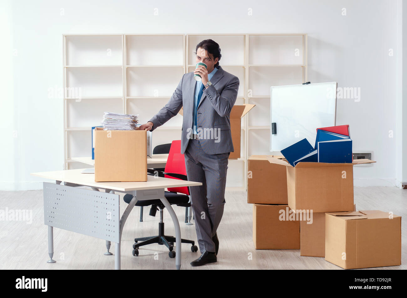 Young man employee with boxes in the office Stock Photo - Alamy