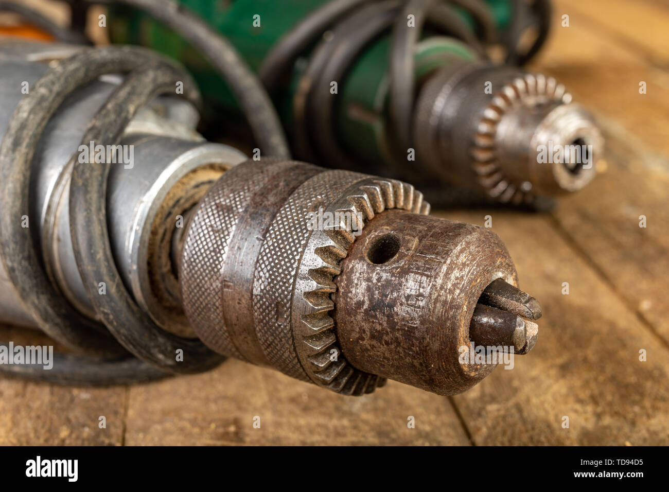 Old drills on a wooden workshop table. Rusty drill holder in an old ...