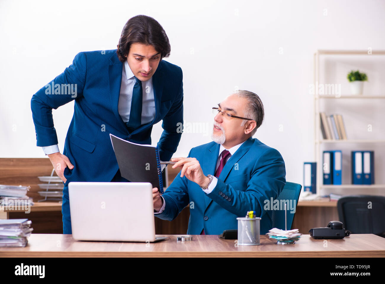 Young and old employees working together in the office Stock Photo - Alamy