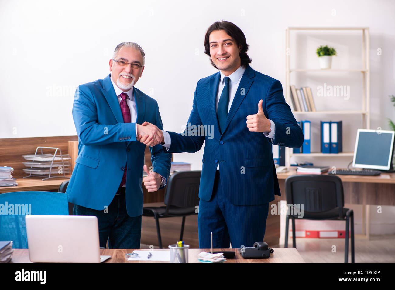 Young and old employees working together in the office Stock Photo - Alamy