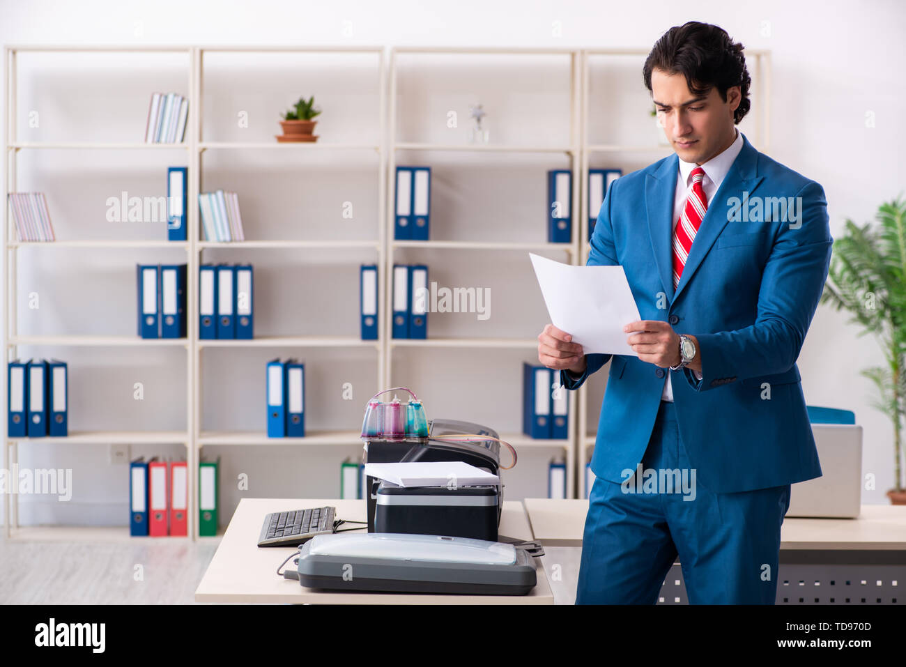 Young employee making copies at copying machine Stock Photo - Alamy