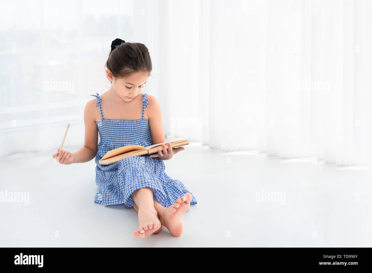 Cute girl reviewing homework and lessons with notebook and wooden ...