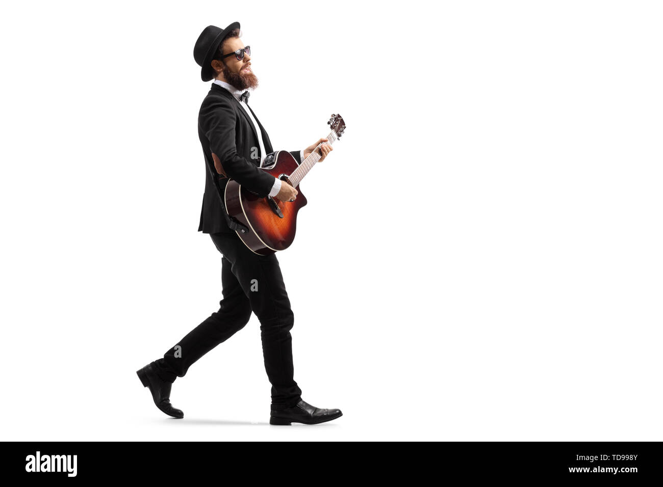 Full length profile shot of a male musician walking and playing an ...