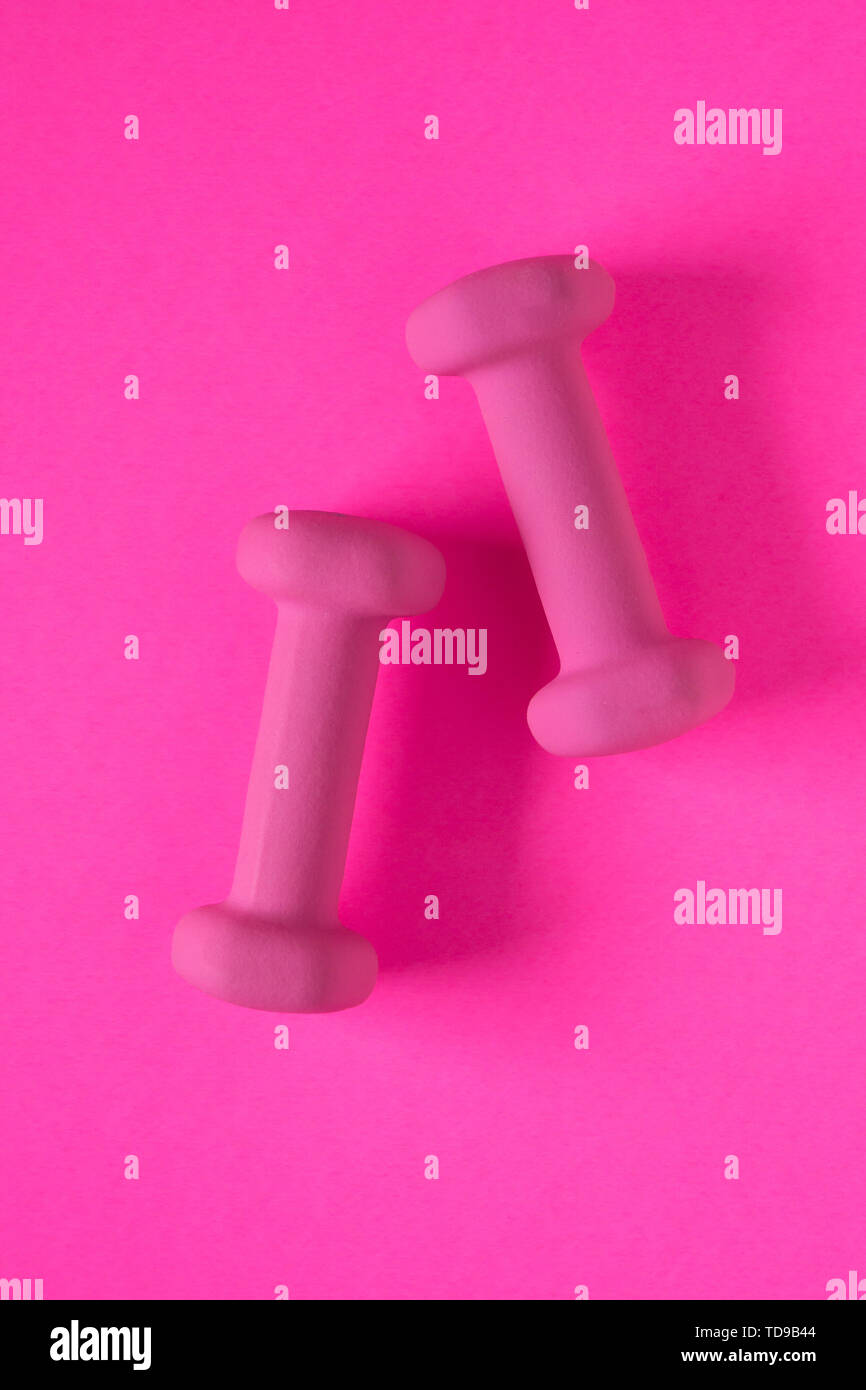 Fitness equipment with womens pink weights/ dumbbells isolated on a ...