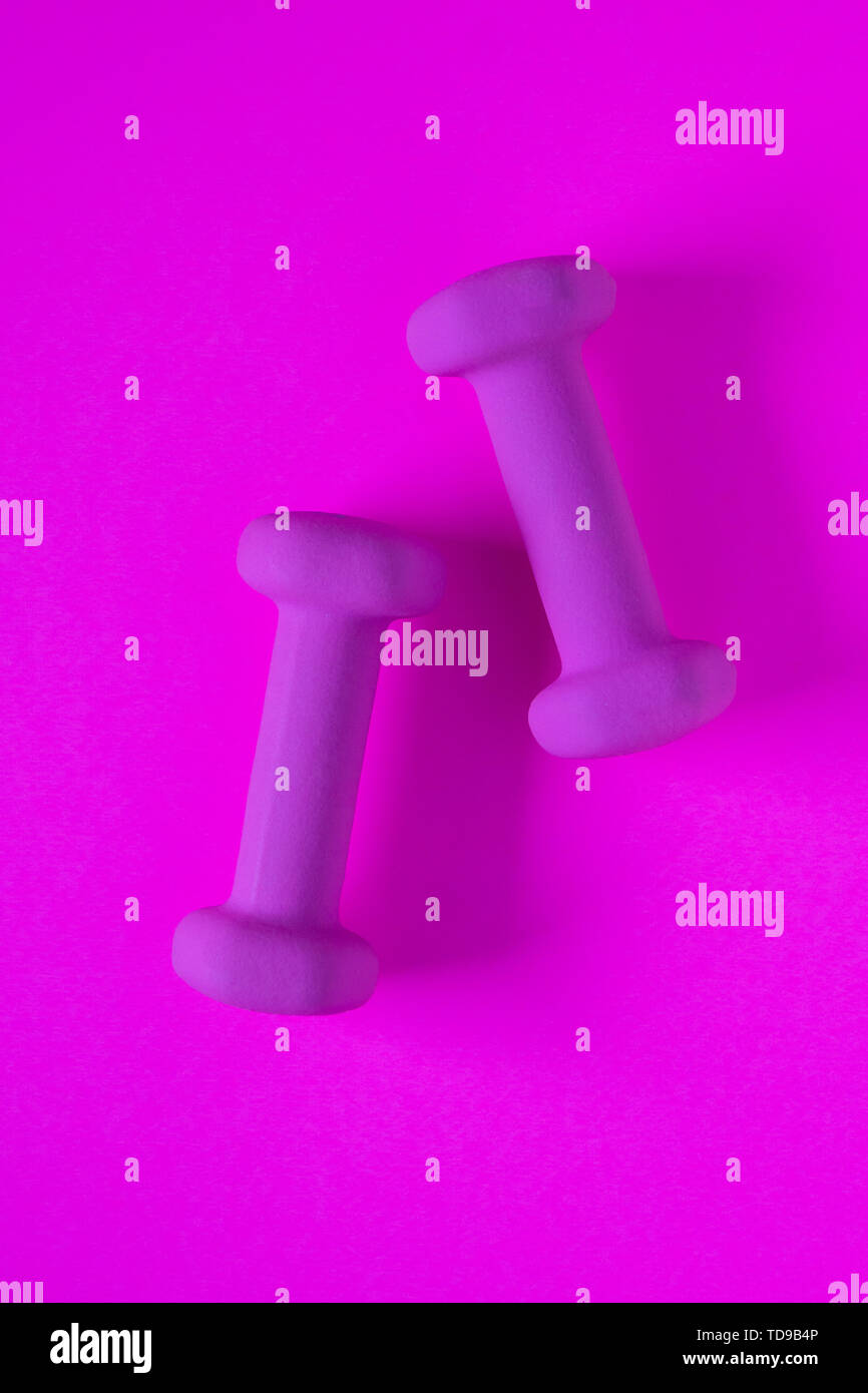 Fitness equipment with womens purple weights/ dumbbells isolated on a ...