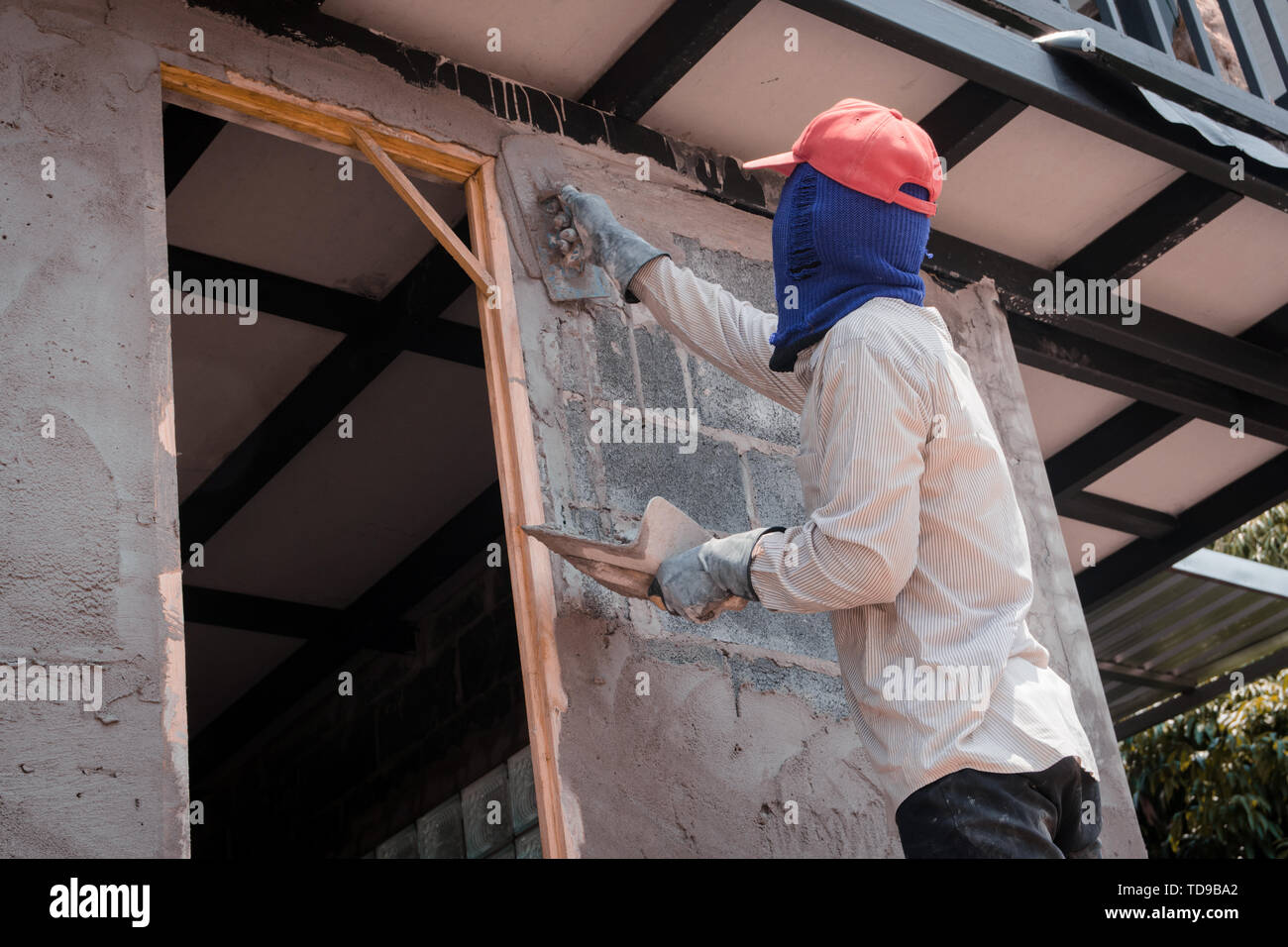 Construction workers plastering building wall using cement plaster ...