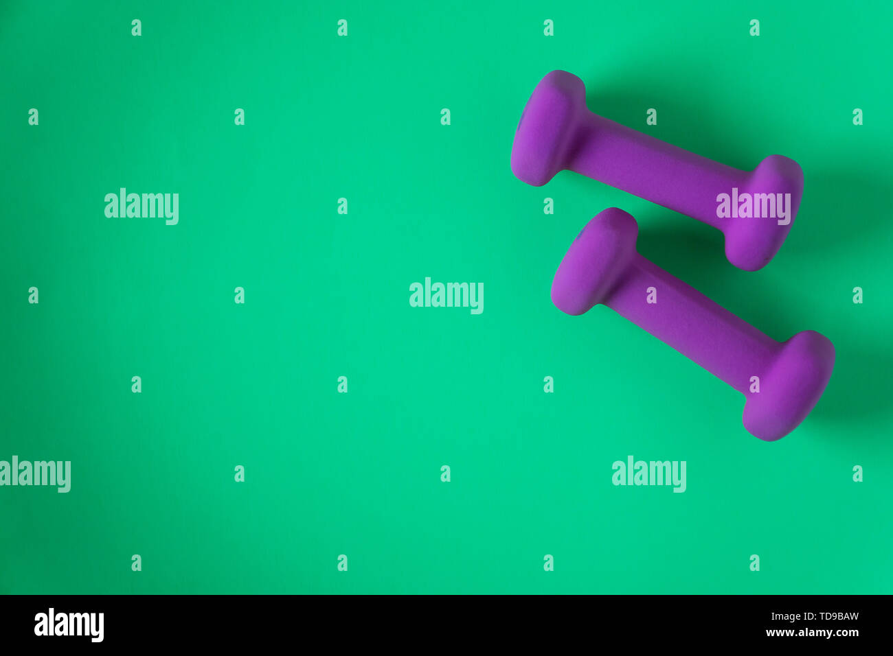 Fitness equipment with womens purple weights/ dumbbells isolated on a ...