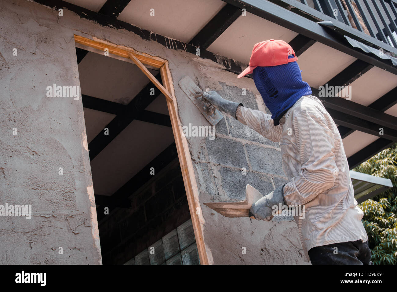Construction workers plastering building wall using cement plaster ...