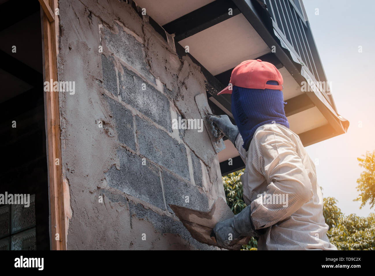 Construction workers plastering building wall using cement plaster ...
