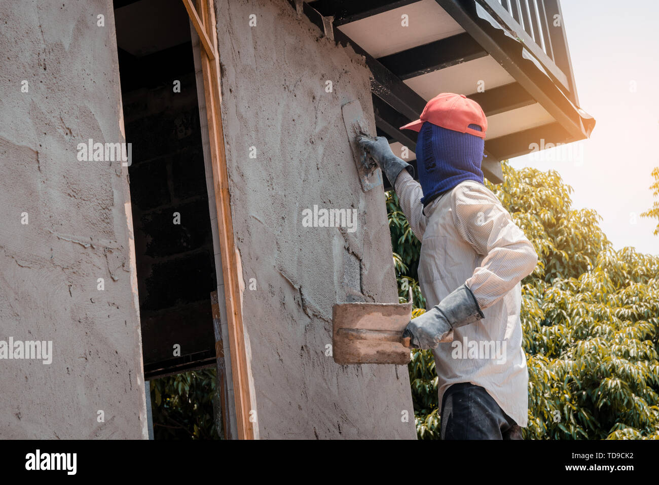 Construction workers plastering building wall using cement plaster ...