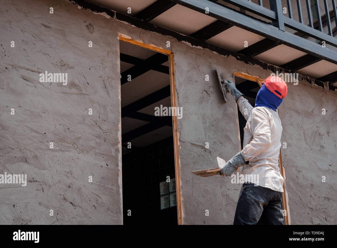Construction workers plastering building wall using cement plaster ...