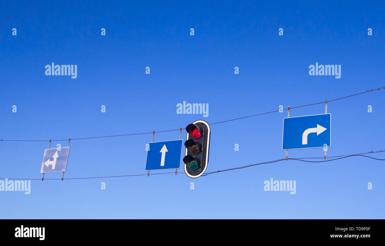 Isolated traffic light showing red and road signs hanging on the rope ...