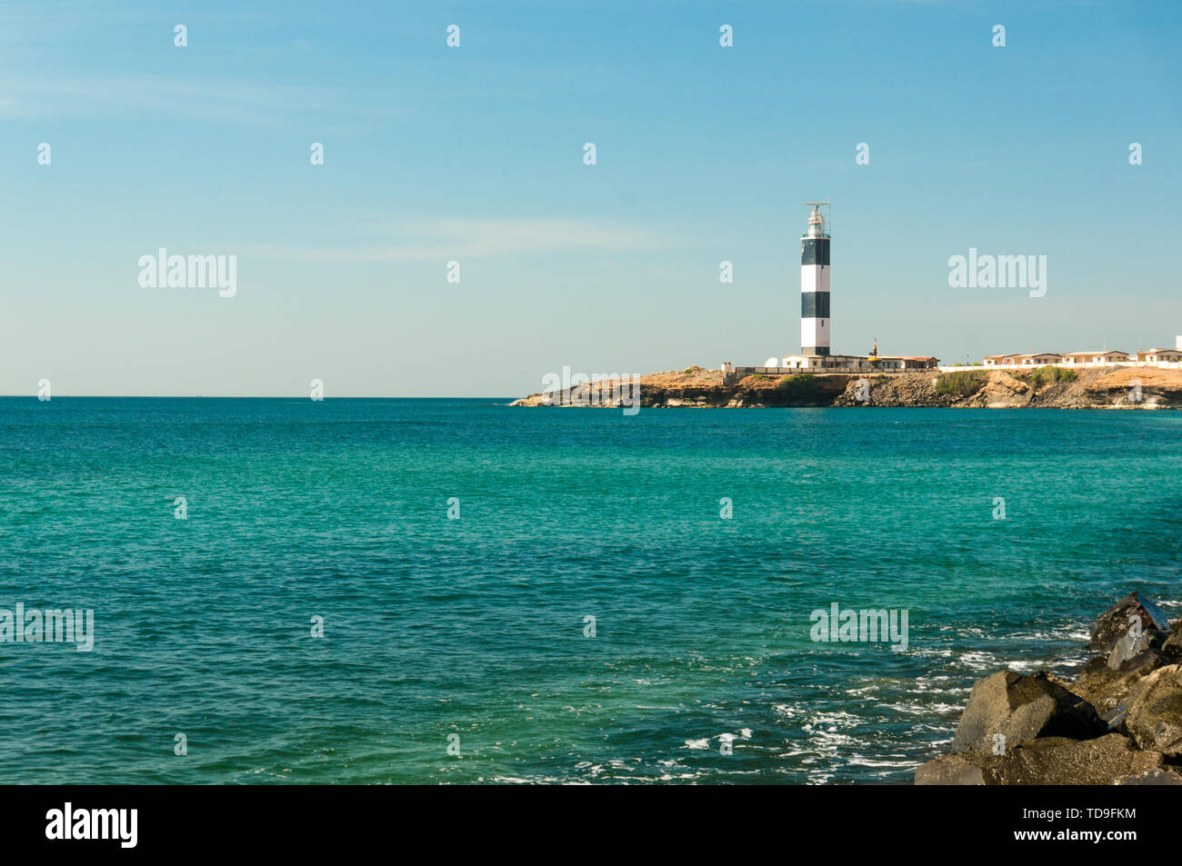 Lighthouse and wave breakers on the coast of the beautiful blue arabian ...