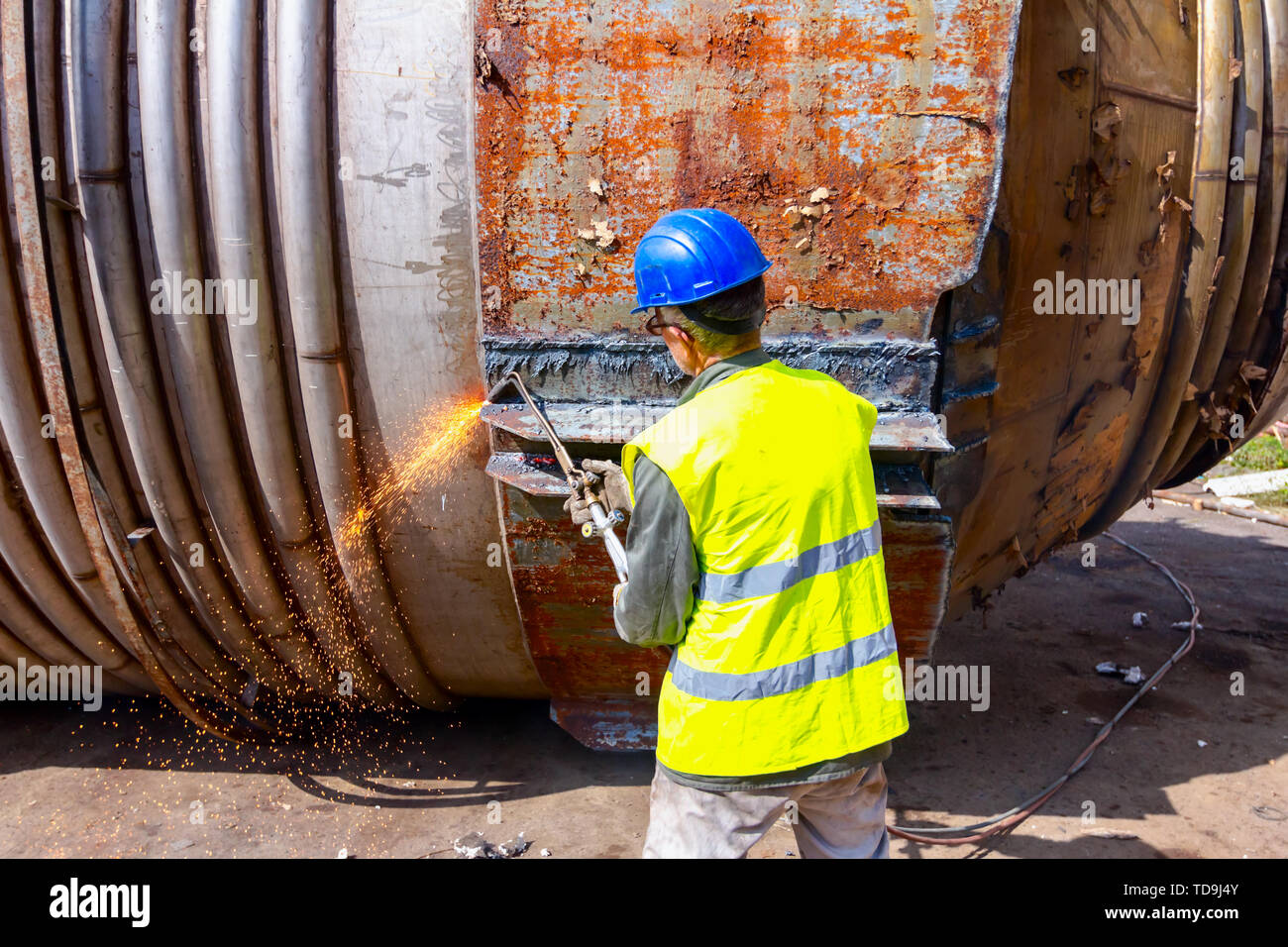 Worker is cutting manually old metal construction using gas mixture of ...