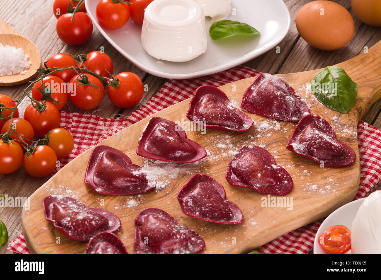 Red heart ravioli with tomato, mozzarella and basil Stock Photo - Alamy