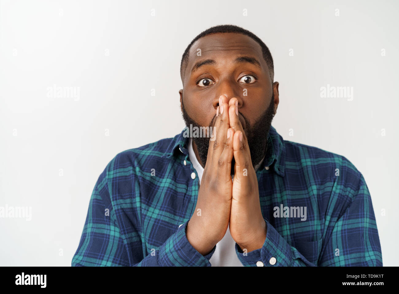 surprised young dark-skinned African American man student staring at camera with shocked look ...