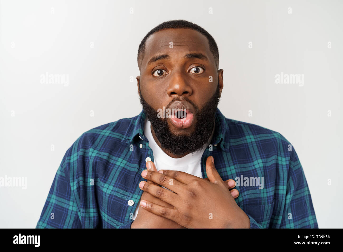 surprised young dark-skinned African American man student staring at camera with shocked look ...