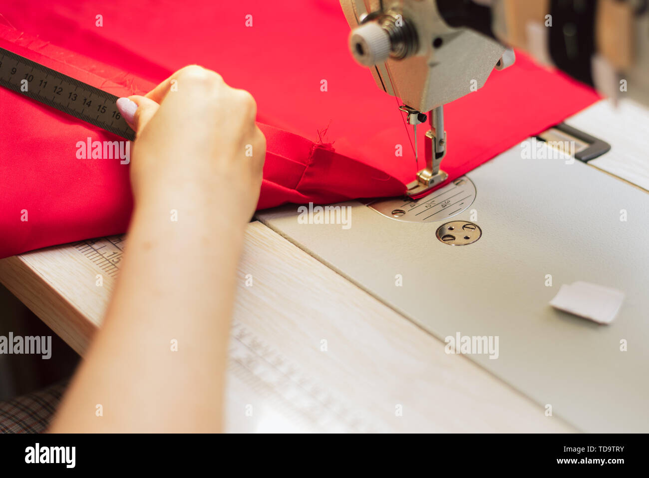 Tailor measures fabric with a ruler. Woman works in a garment factory ...