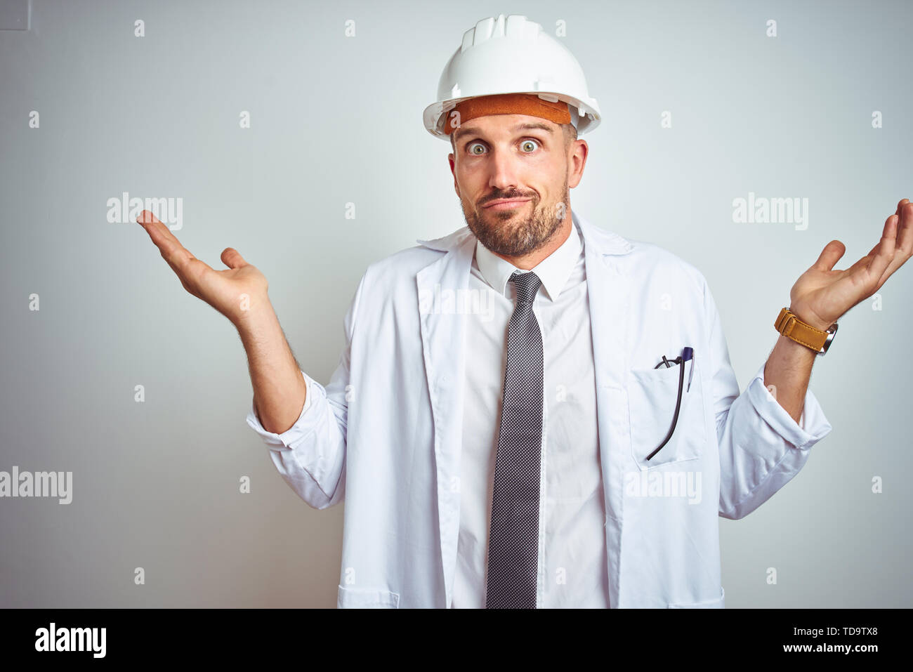 Young handsome engineer man wearing safety helmet over isolated ...