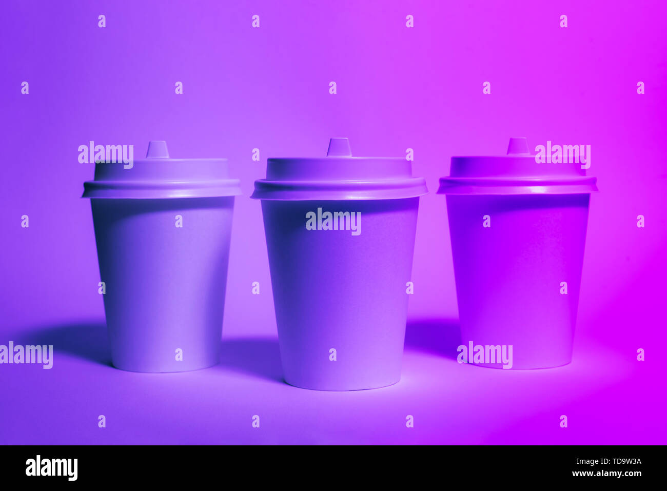 Paper disposable cups in trendy neon light Stock Photo - Alamy