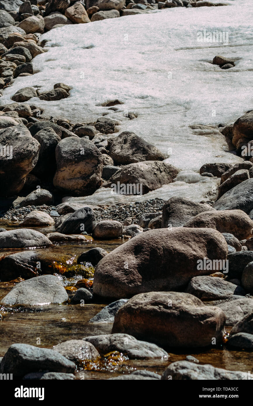 stones covered with snow and river movement Stock Photo - Alamy