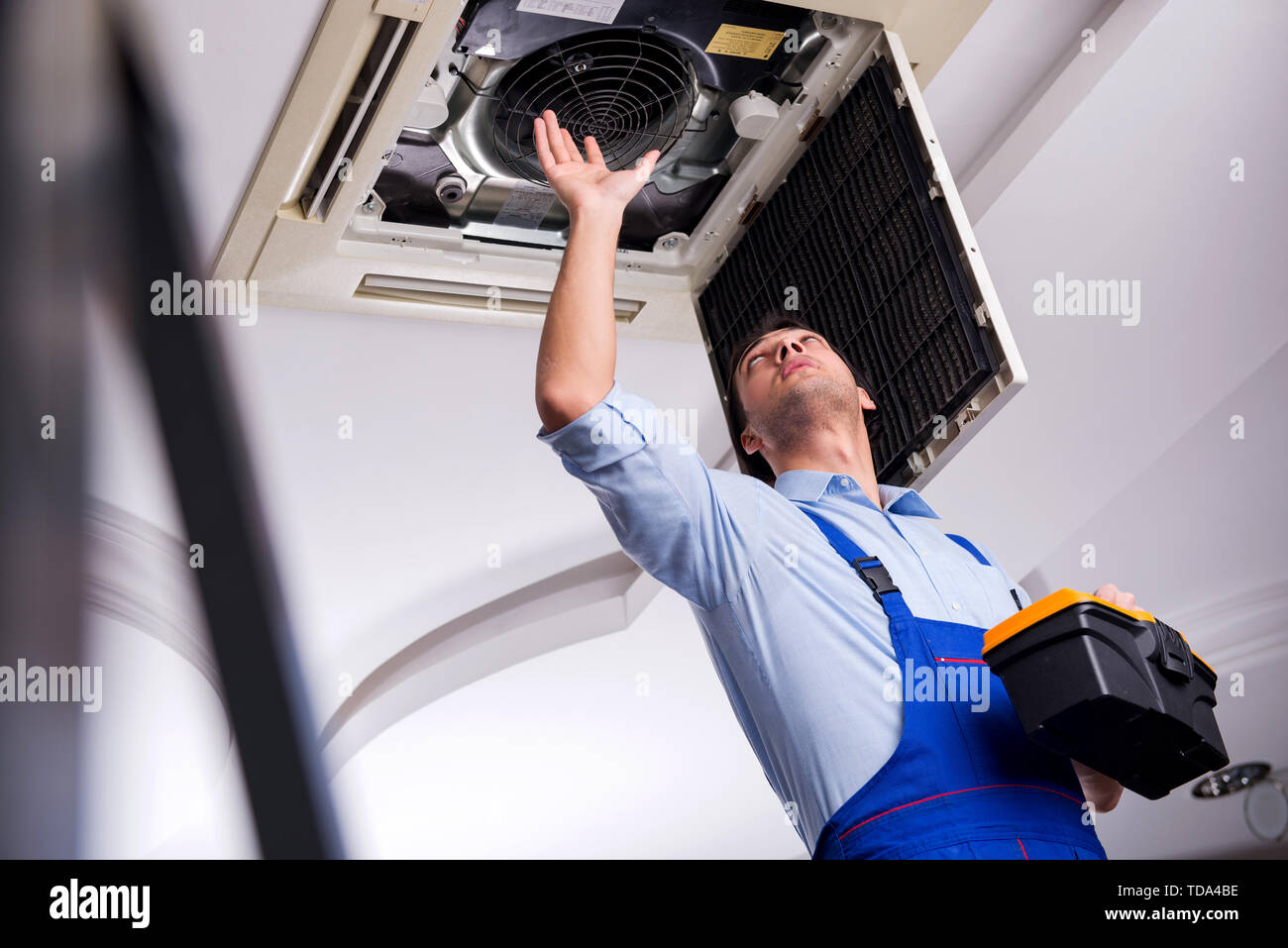 Young repairman repairing ceiling air conditioning unit Stock Photo - Alamy