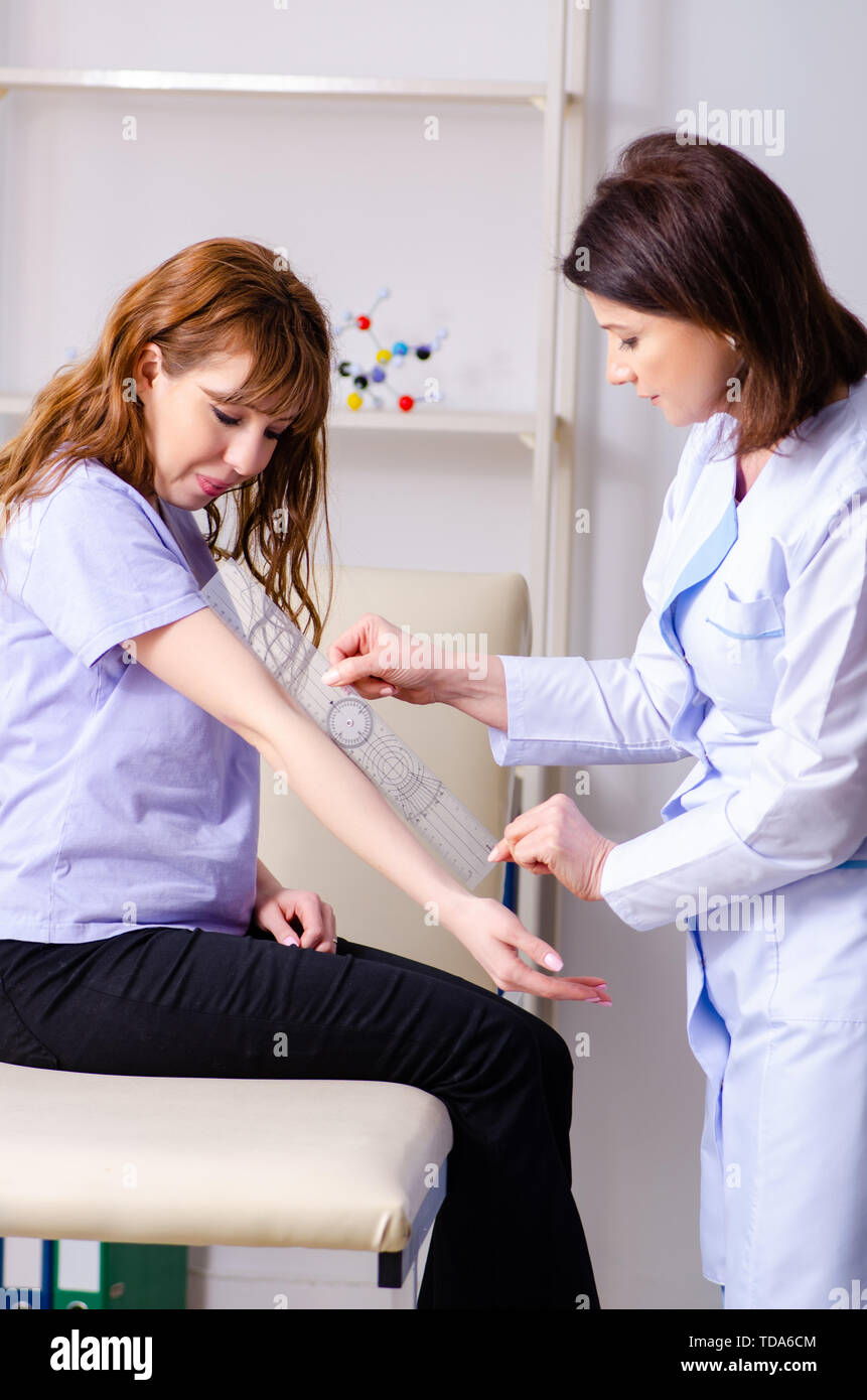 Female doctor checking patient's joint flexibility with goniometer ...