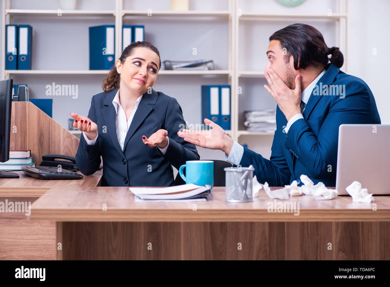 Two employees suffering at workplace Stock Photo - Alamy