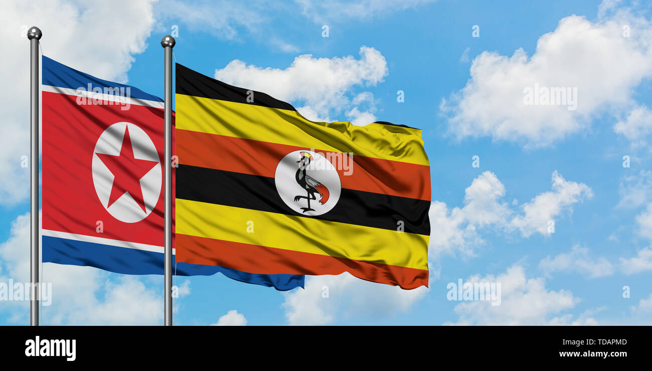 North Korea and Uganda flag waving in the wind against white cloudy ...