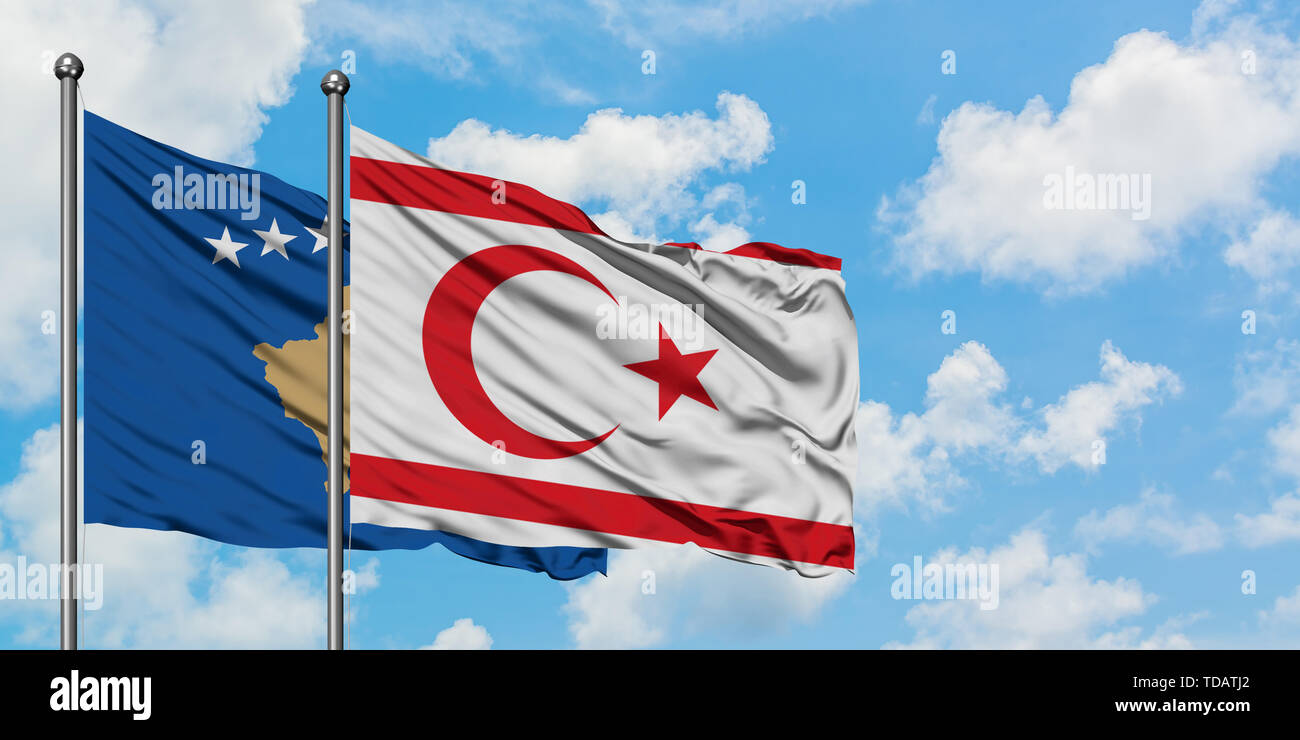 Kosovo and Northern Cyprus flag waving in the wind against white cloudy ...