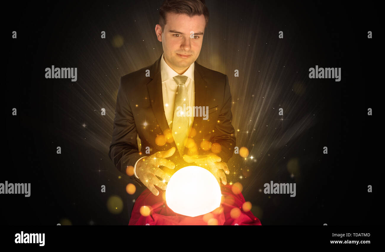 Gorgeous businessman sitting with sparkling magic ball in his lap Stock ...