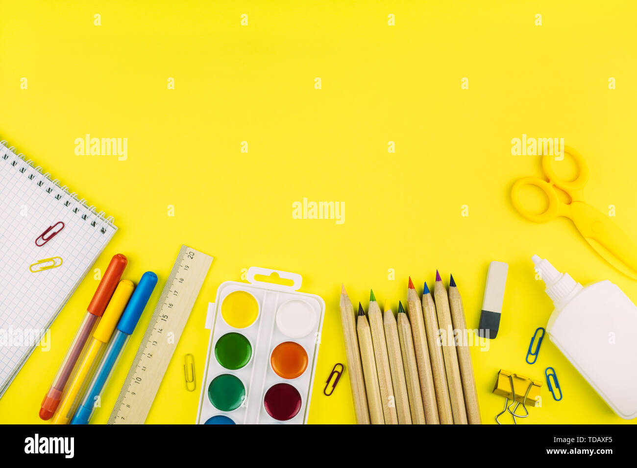 Different school supplies on bright yellow paper background Stock Photo ...